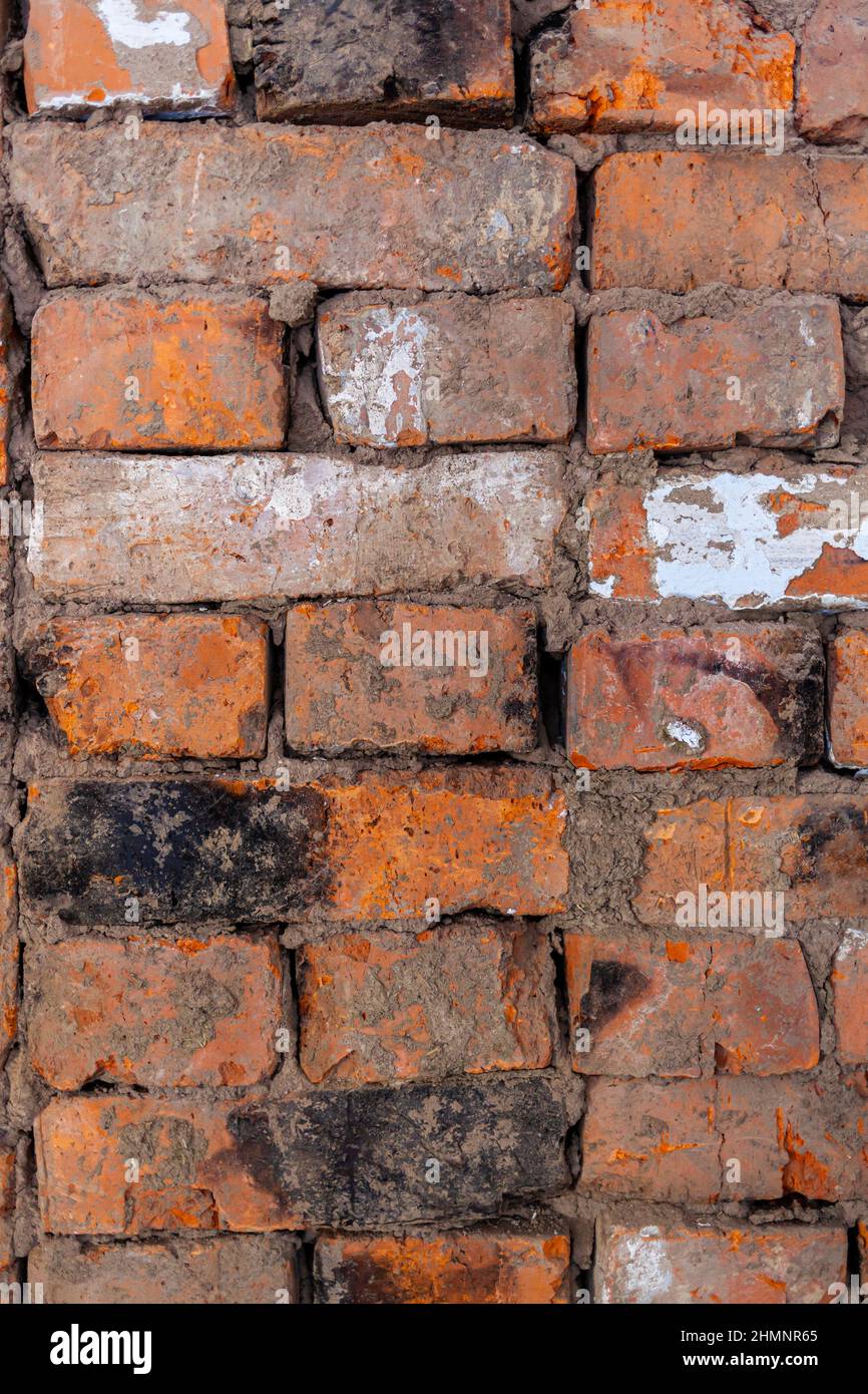 Repair of an old brick wall of a home stove. Different red bricks are ...