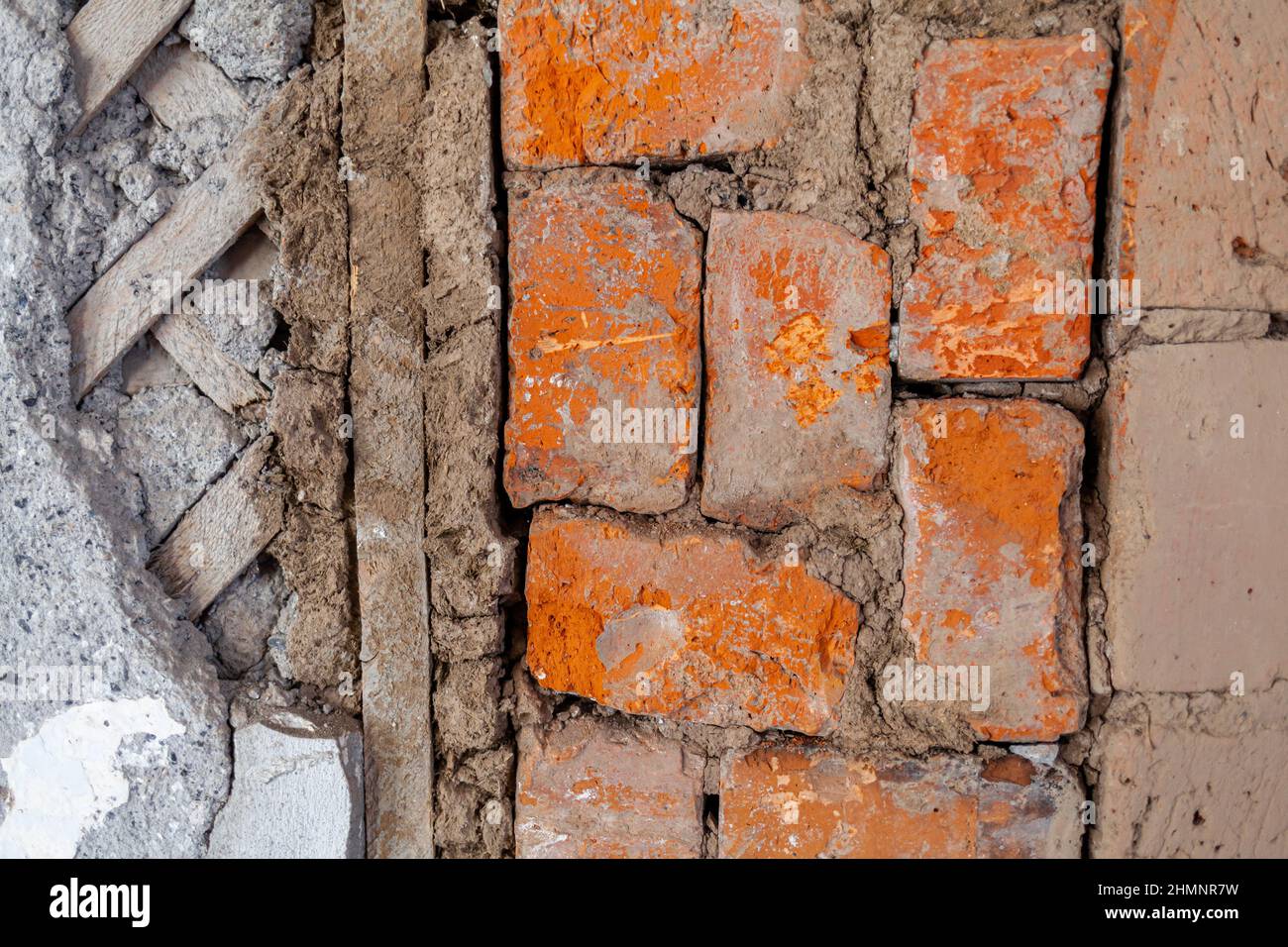 Repair of an old brick wall of a home stove. Different red bricks are ...