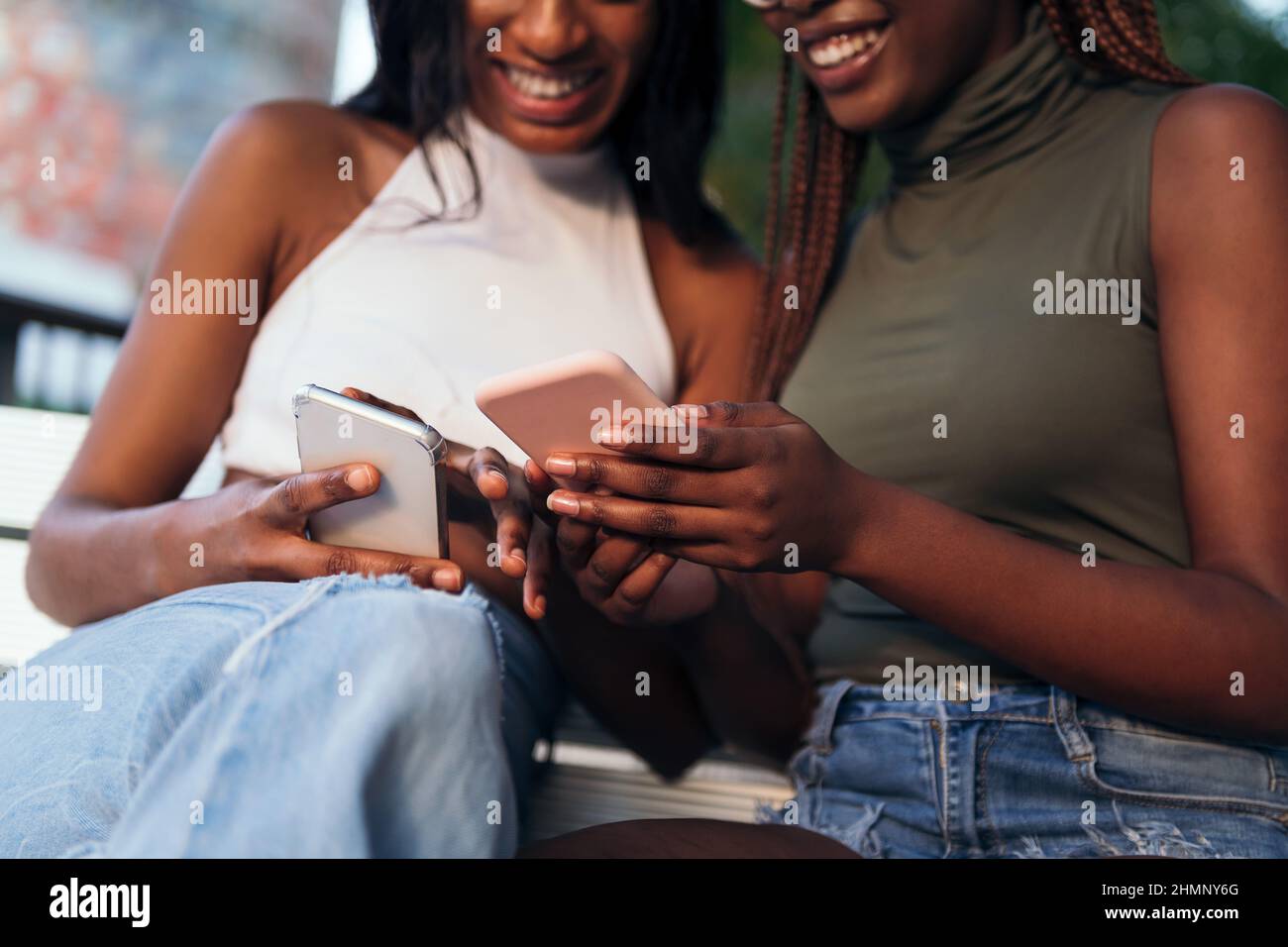 detail of the hands of two unrecognizable smiling black women looking ...