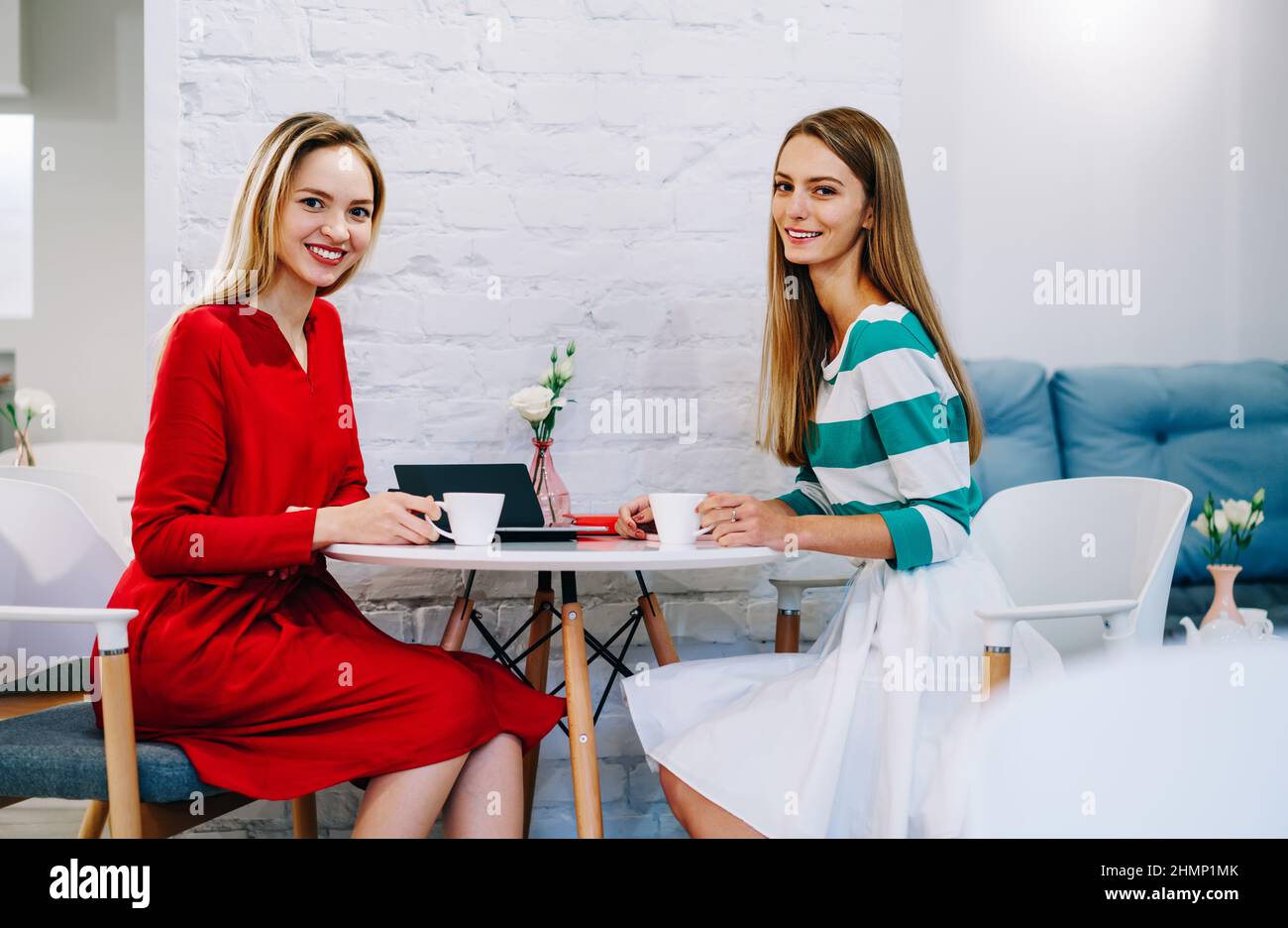 Cheerful female colleagues talking during coffee break Stock Photo - Alamy