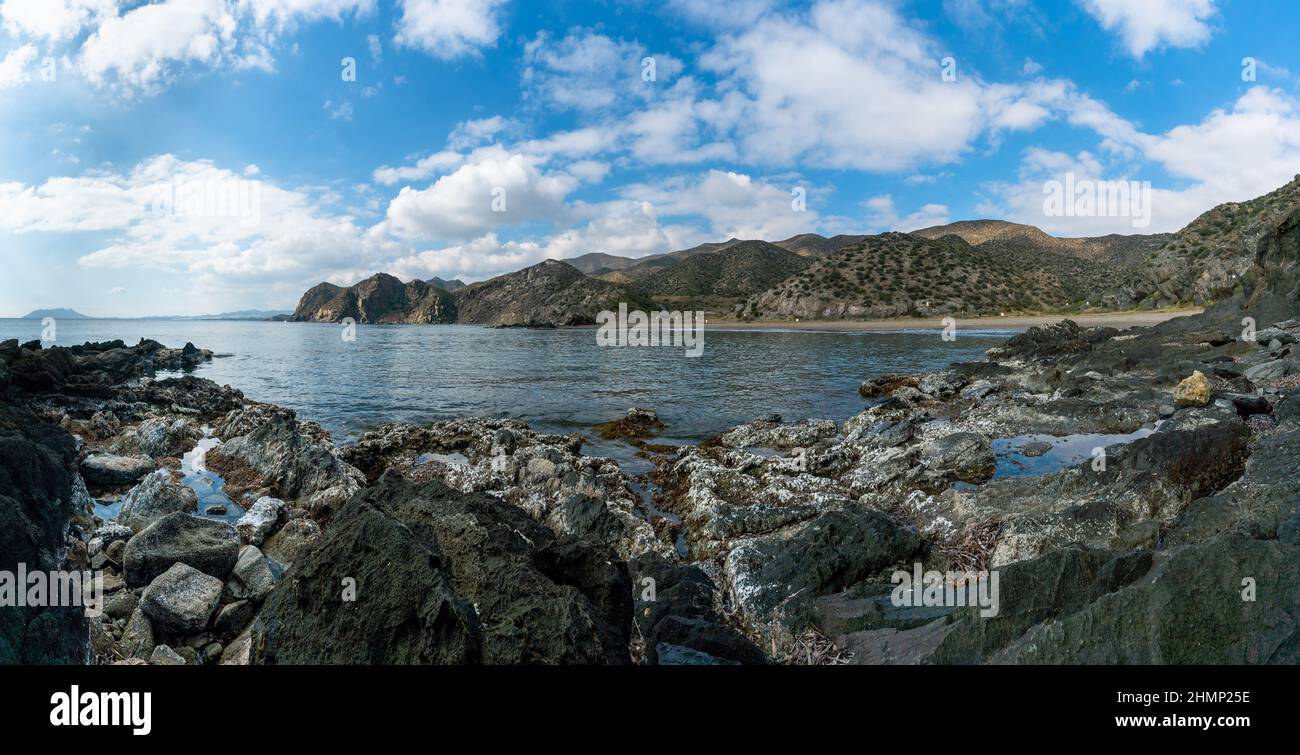 A secluded rocky cove on a wild mountainous coastline with rocks and ...