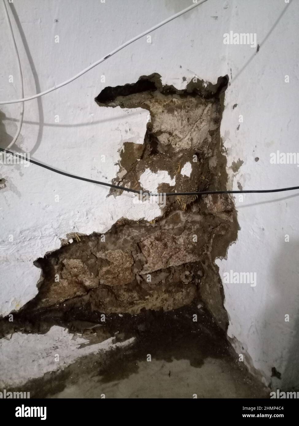 Renovation in a room with clay plaster. Peeling plaster from the wall ...
