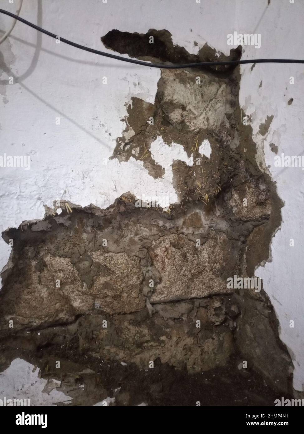 Renovation in a room with clay plaster. Peeling plaster from the wall ...