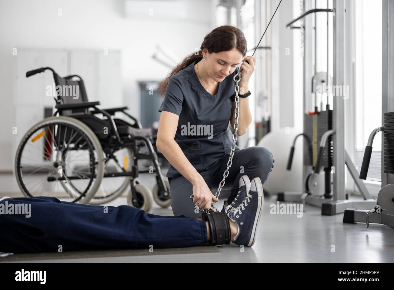 Rehabilitation specialist helps a guy to do exercise on decompression ...