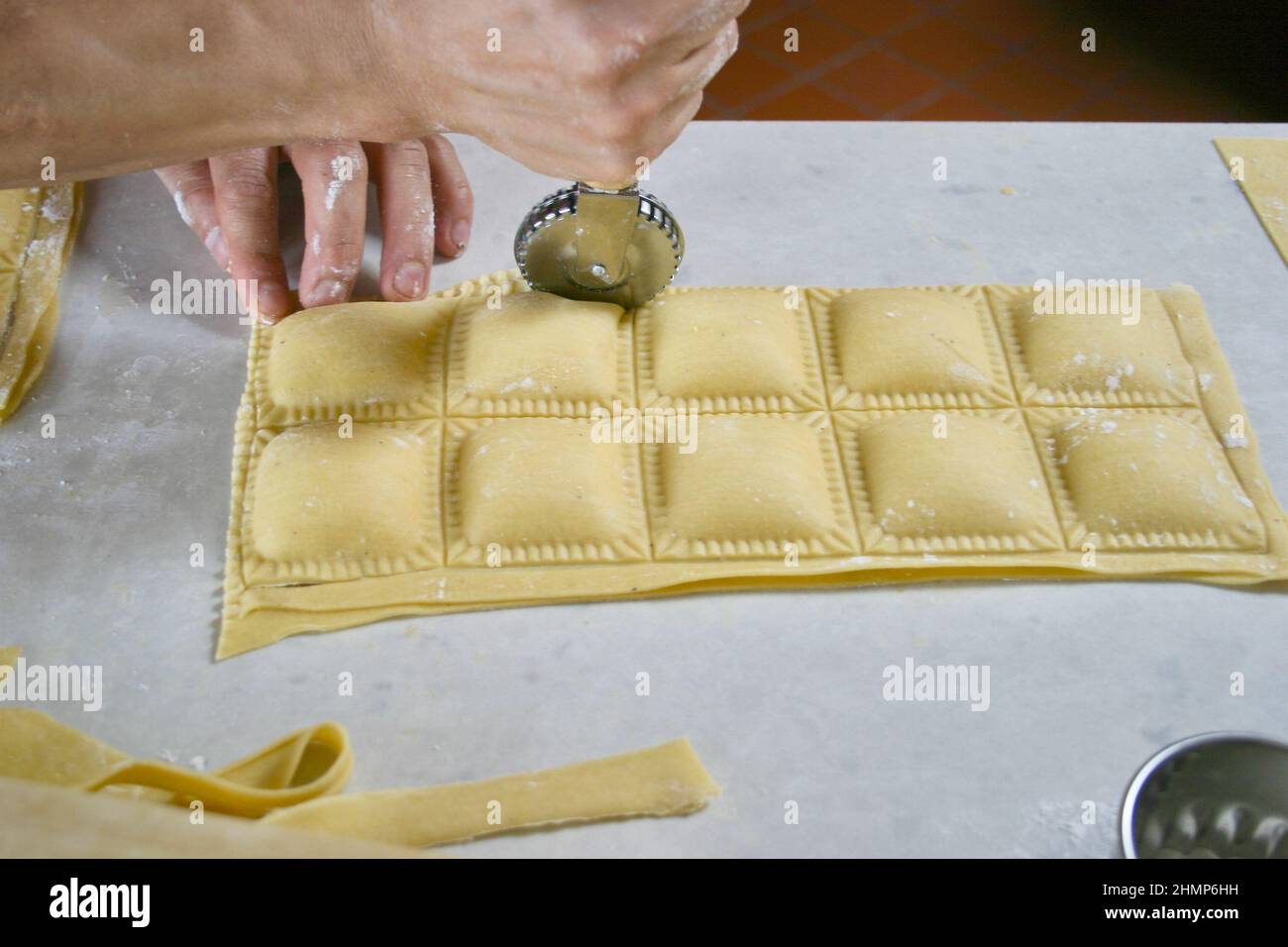 chef using cutting wheel on homemade ravioli Stock Photo - Alamy
