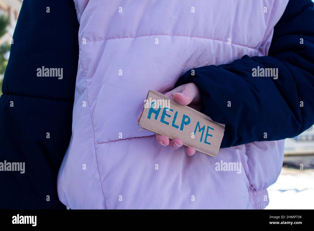 Woman holding cardboard with help me text Stock Photo - Alamy