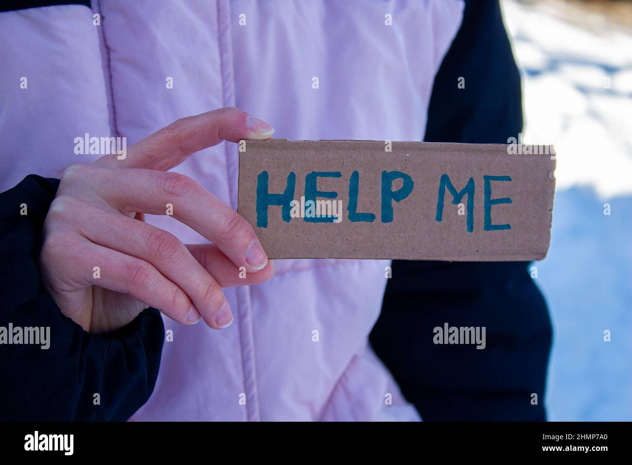 Woman holding cardboard with help me text Stock Photo - Alamy