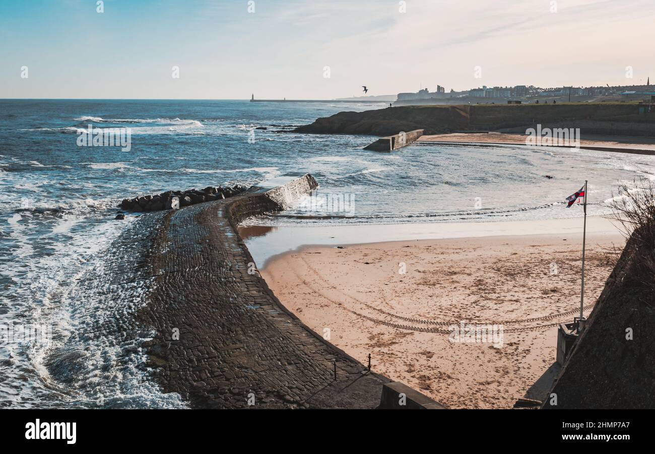 The waves crashing over the Victoria sea wall at Cullercoats Harbour ...