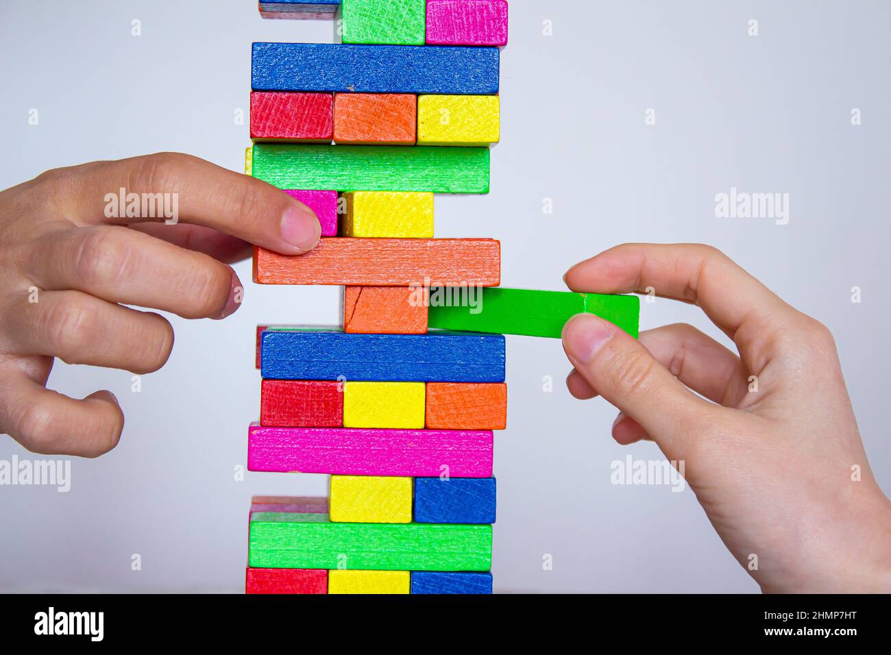 Playing wooden tower game, hand holding wooden game block isolated on ...