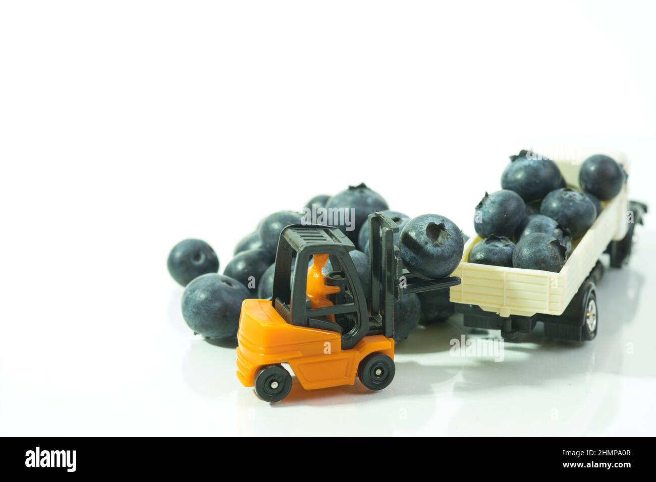 a forklift loads a light truck with blueberries Stock Photo - Alamy