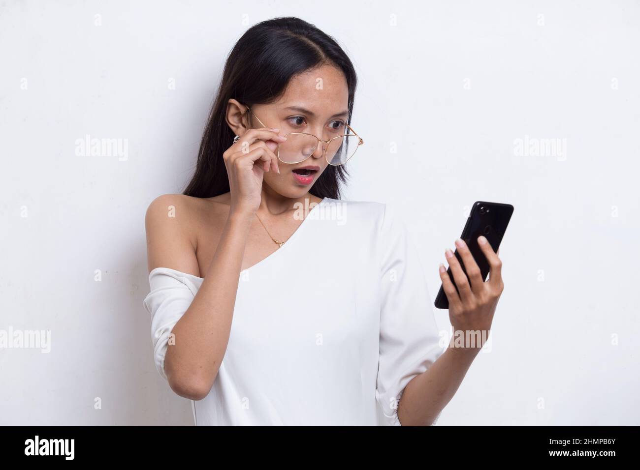 shock young asian beautiful woman using mobile phone isolated on white background Stock Photo ...