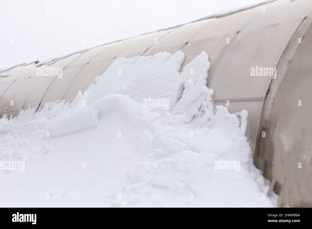 greenhouse covered with white snow and ice in winter, farming snow ...