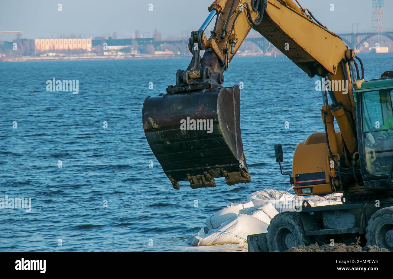 Excavator works to strengthen the embankment. Hydraulic excavator ...