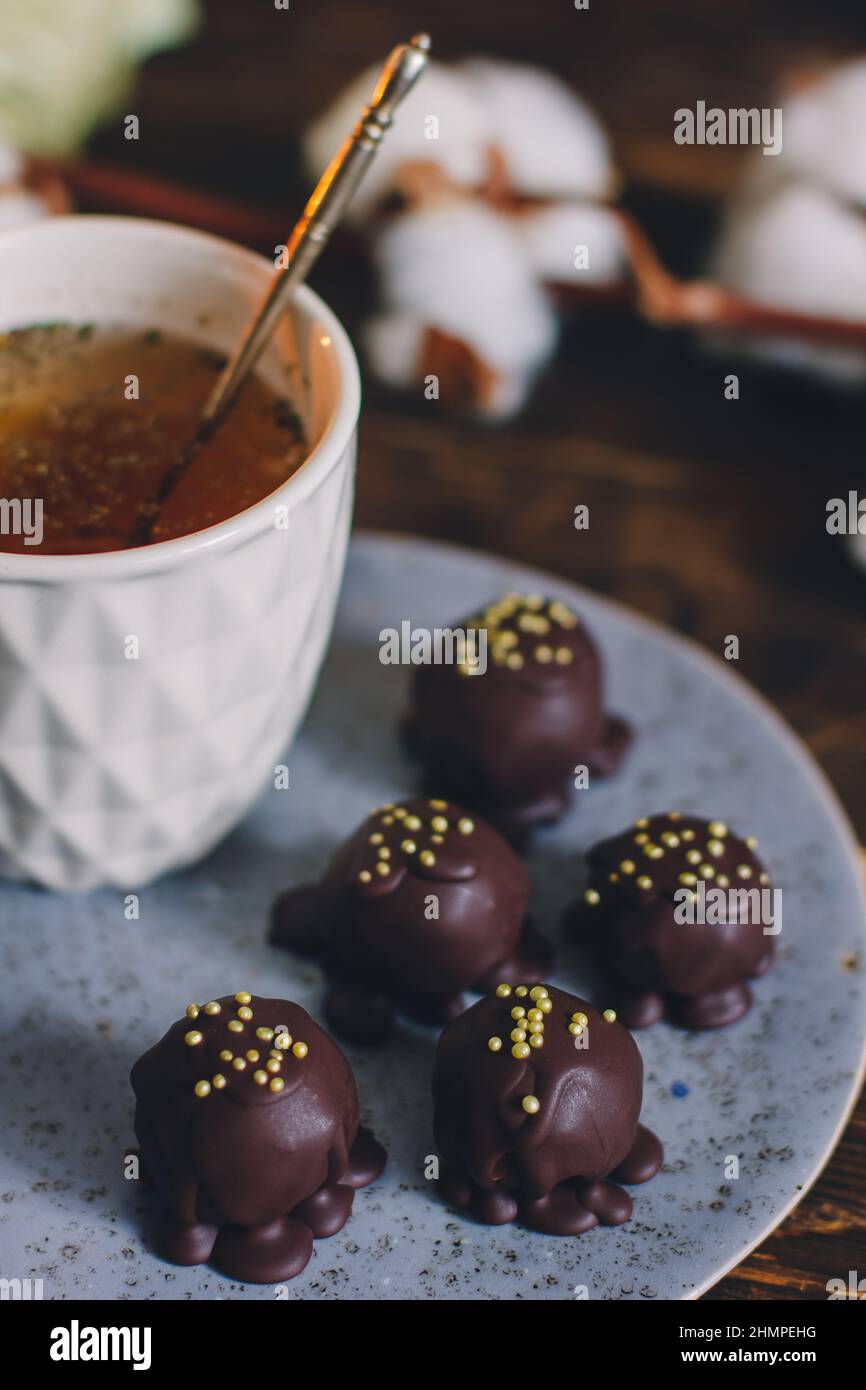 Dark chocolate handmade candy balls on handmade plate on dark wooden ...