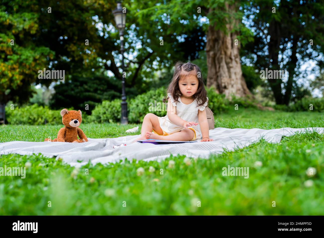 Little baby girl playing with book for children Stock Photo - Alamy