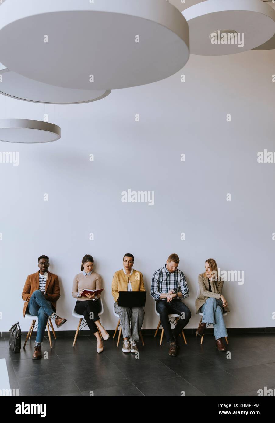 Group of bored young people waiting for the job interview Stock Photo ...