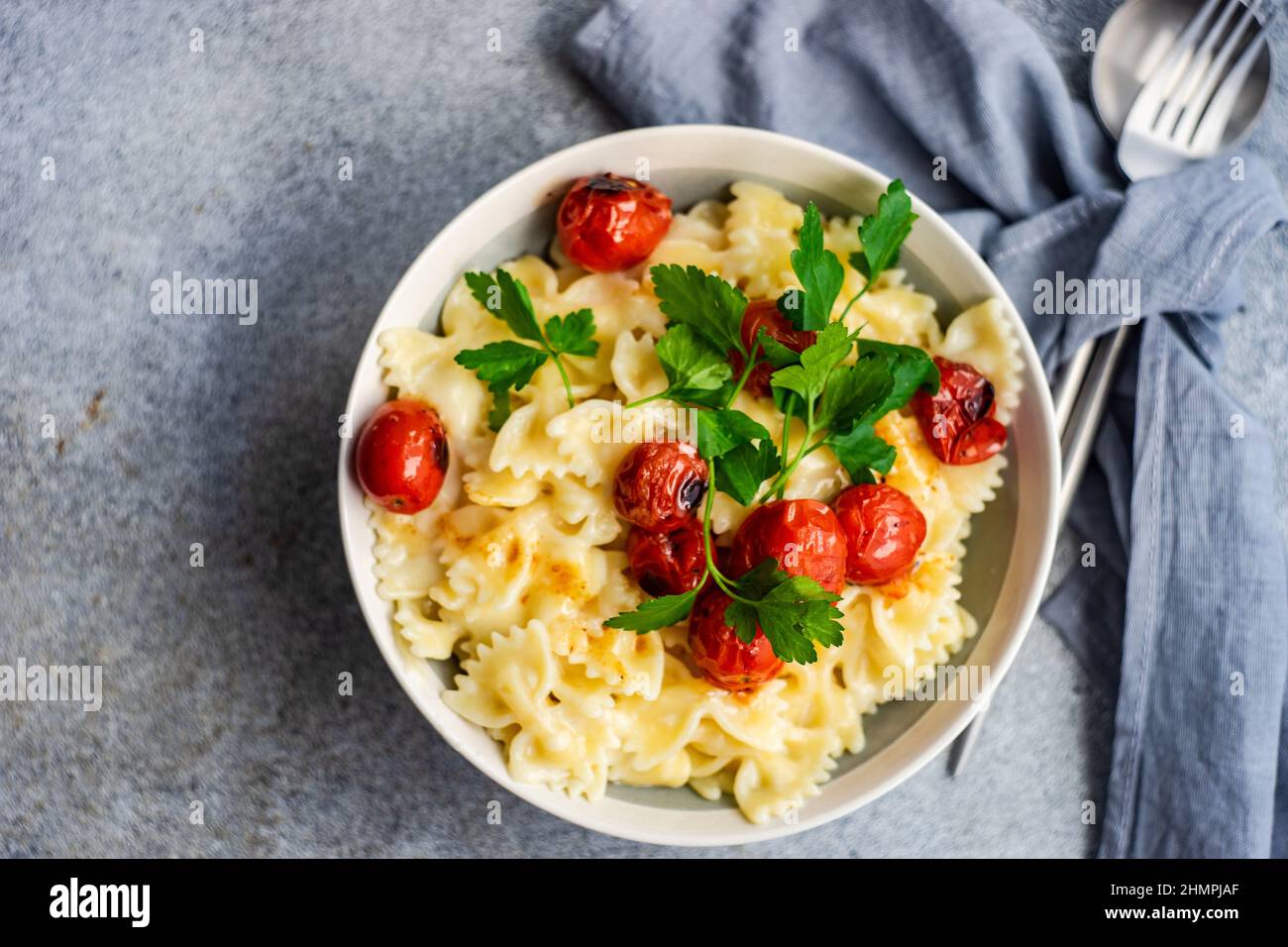Overhead view of a bowl of farfalle pasta with roasted tomatoes and ...