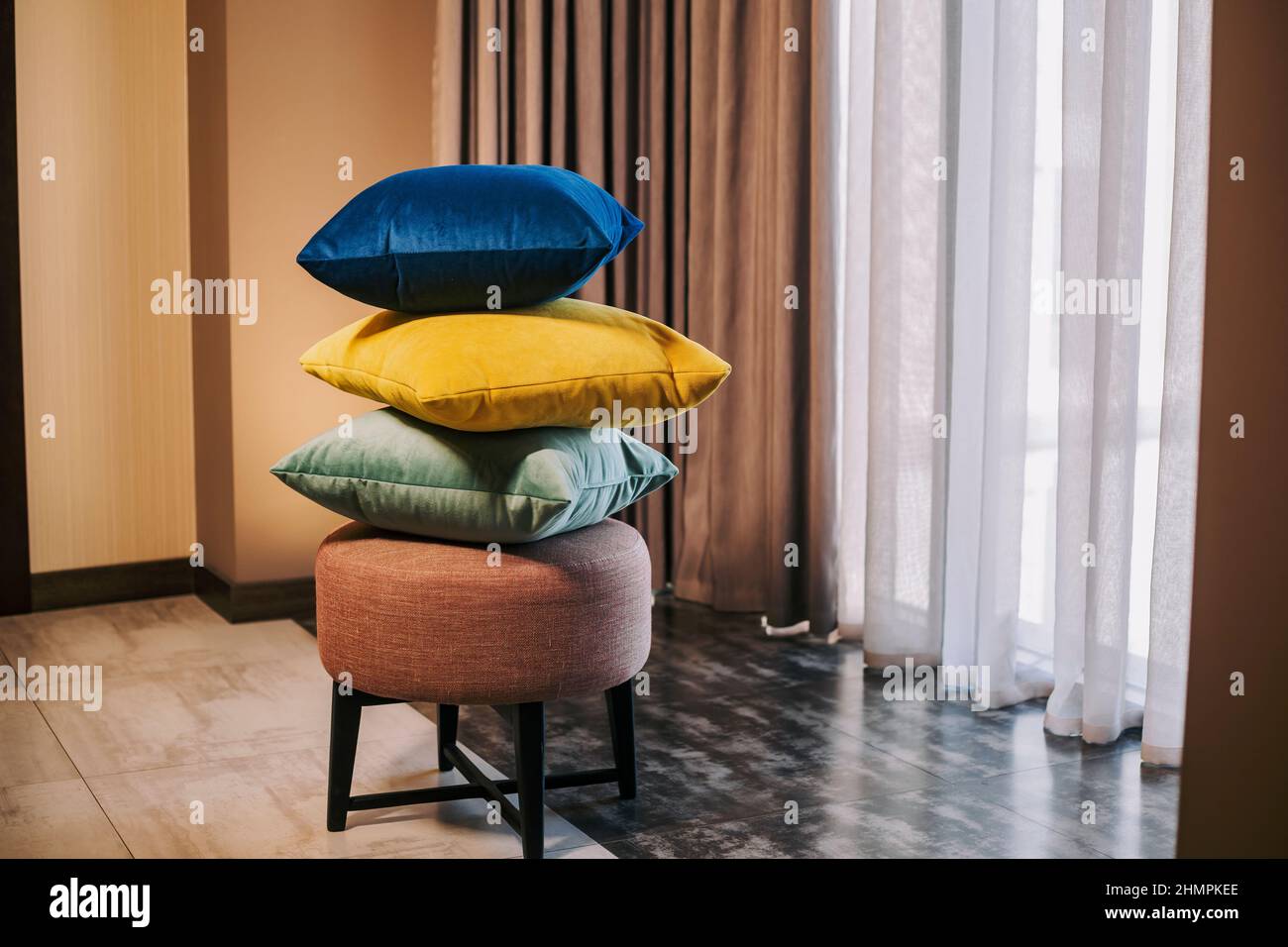Pile of colorful pillows on padded stool next to the windows. Interior ...