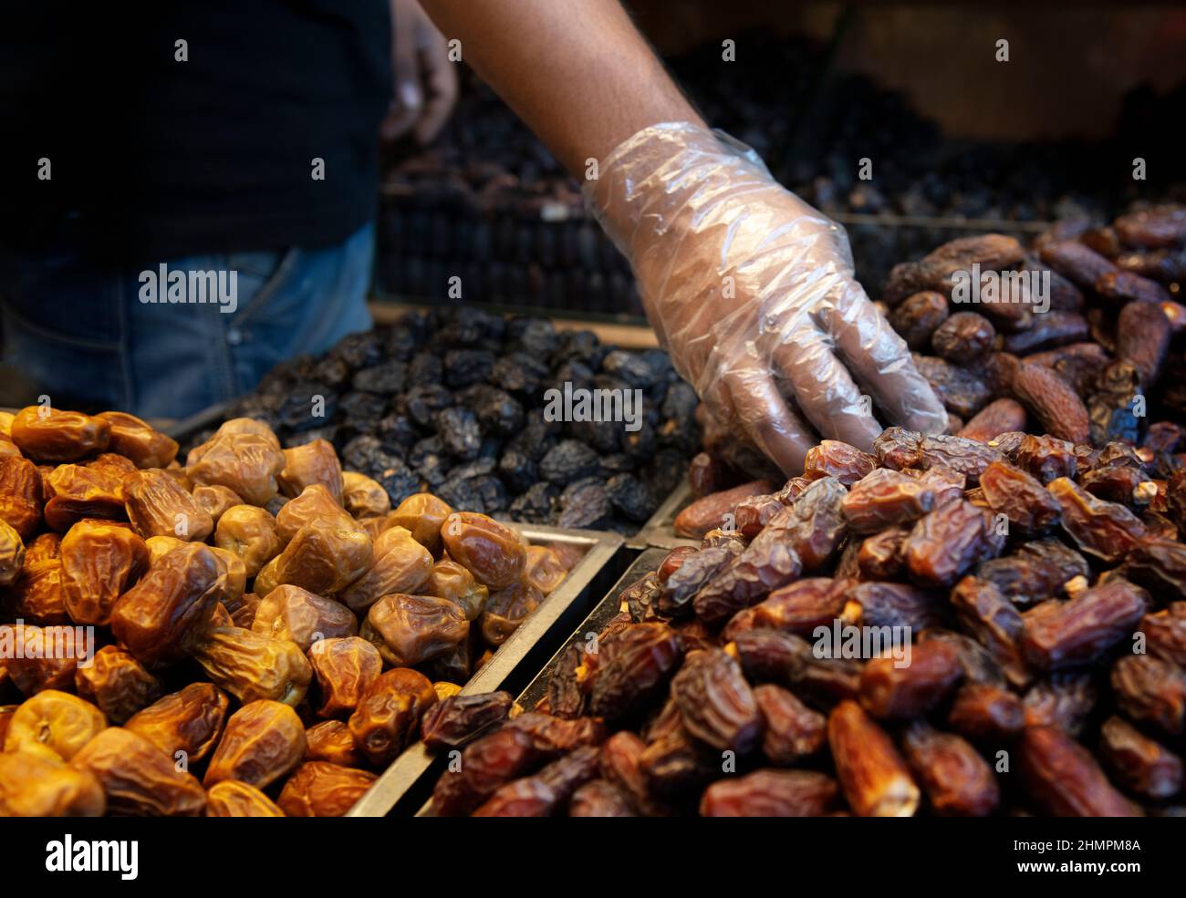 Market vendor's hand picking dates in food market, Saudi Arabia Stock ...
