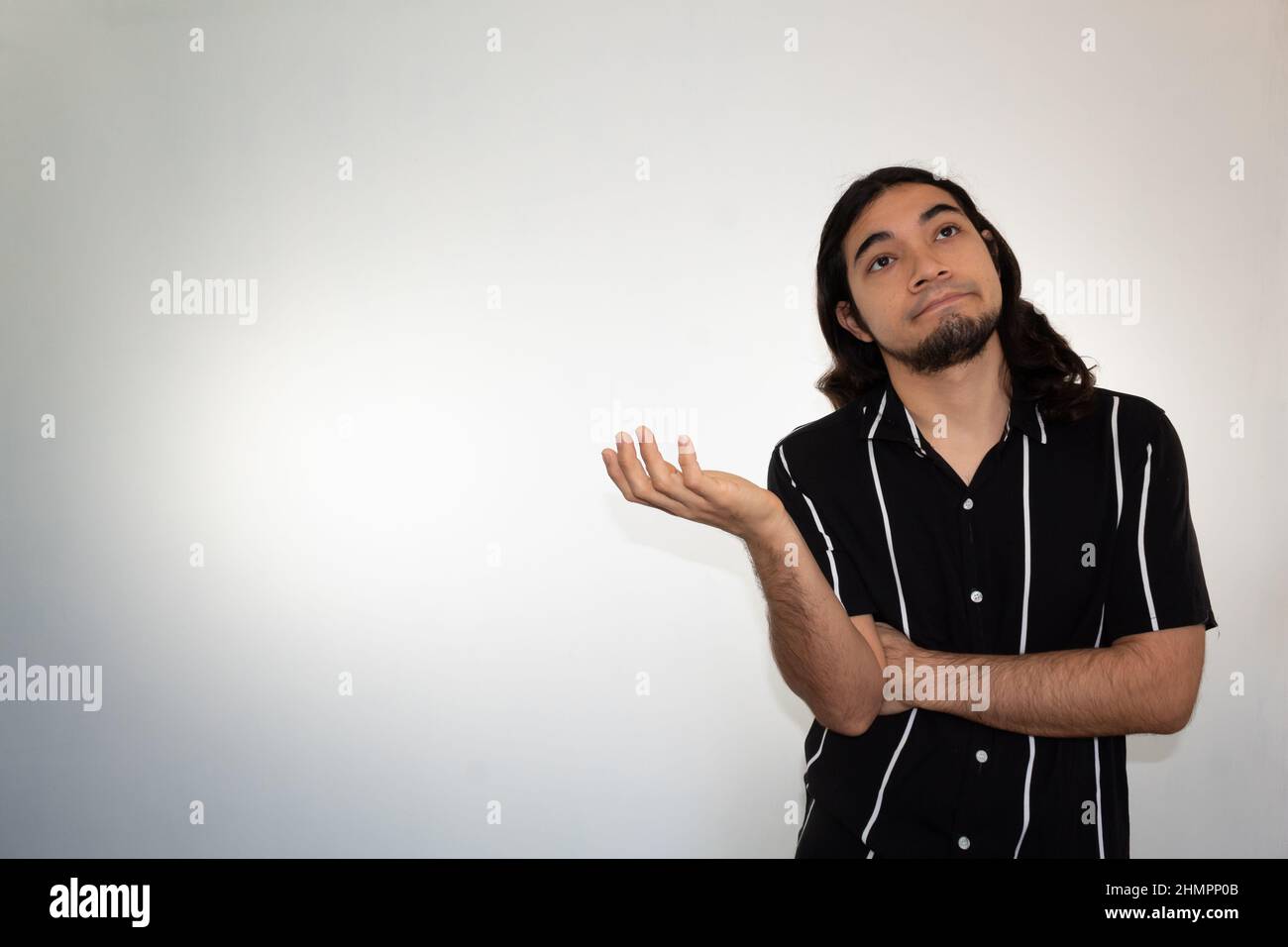 non binary hispanic man with a thoughtful attitude on a white ...