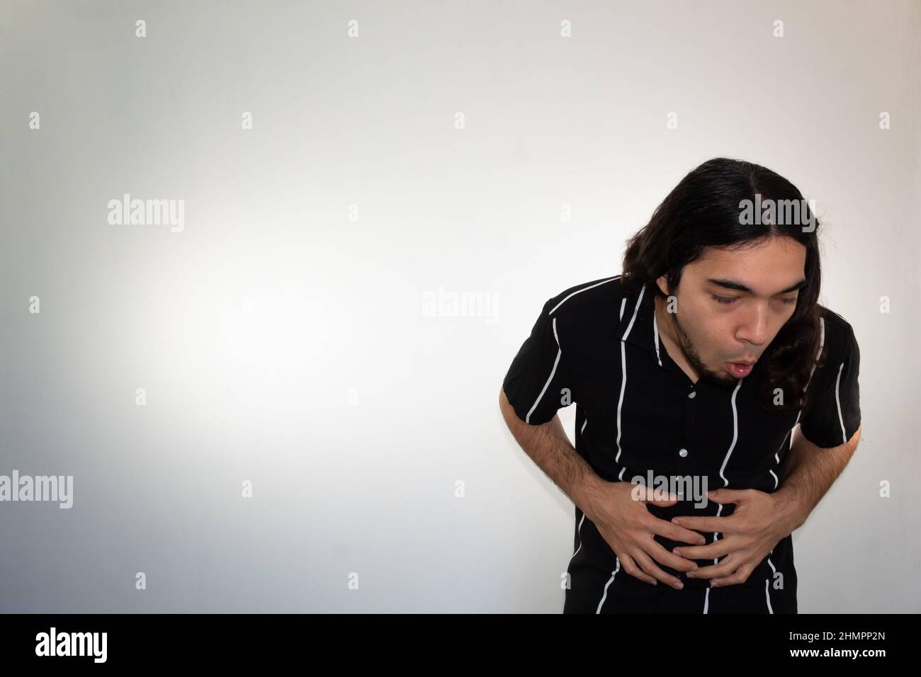 hispanic man with a lot of disgust and nausea on a white background ...