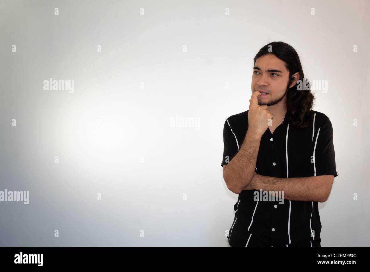non binary hispanic man with a thoughtful attitude on a white ...
