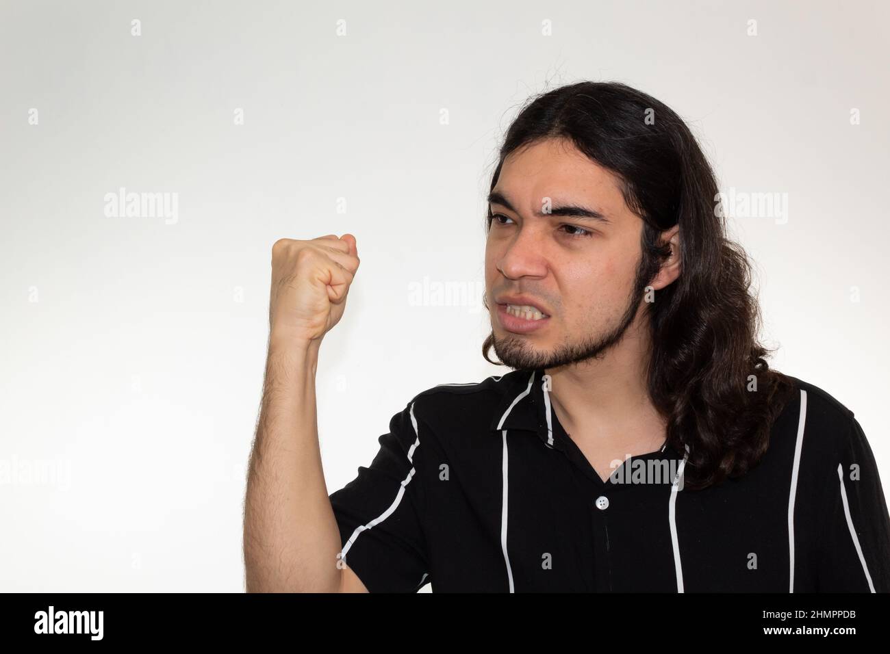 portrait of a very angry, furious and upset hispanic man on a white ...
