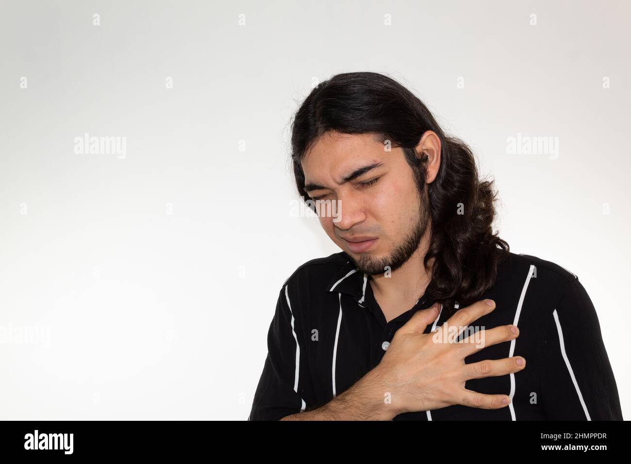 non binary hispanic man with chest pain and heart attack on a white ...