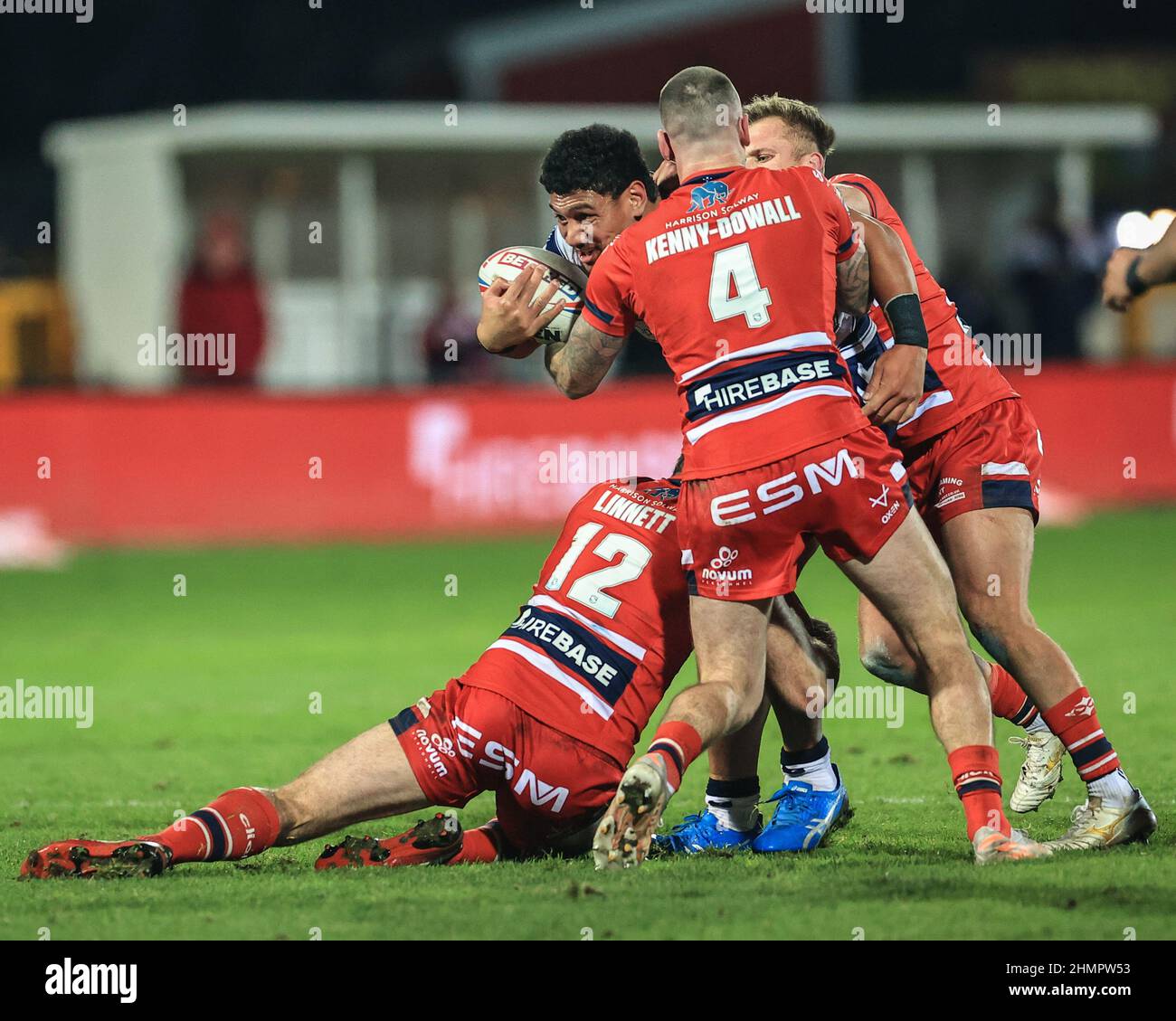 Patrick Mago #10 of Wigan Warriors is tackled by Kane Linnett #12 of ...