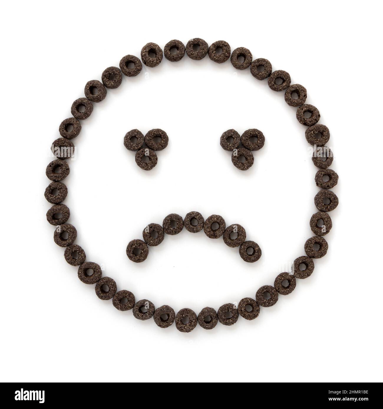 crunchy cereal rings breakfast in the shape of sad face on white ...
