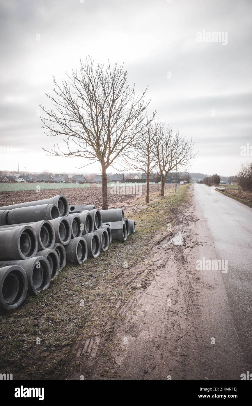on a roadside there are concrete pipes that are to be laid Stock Photo ...