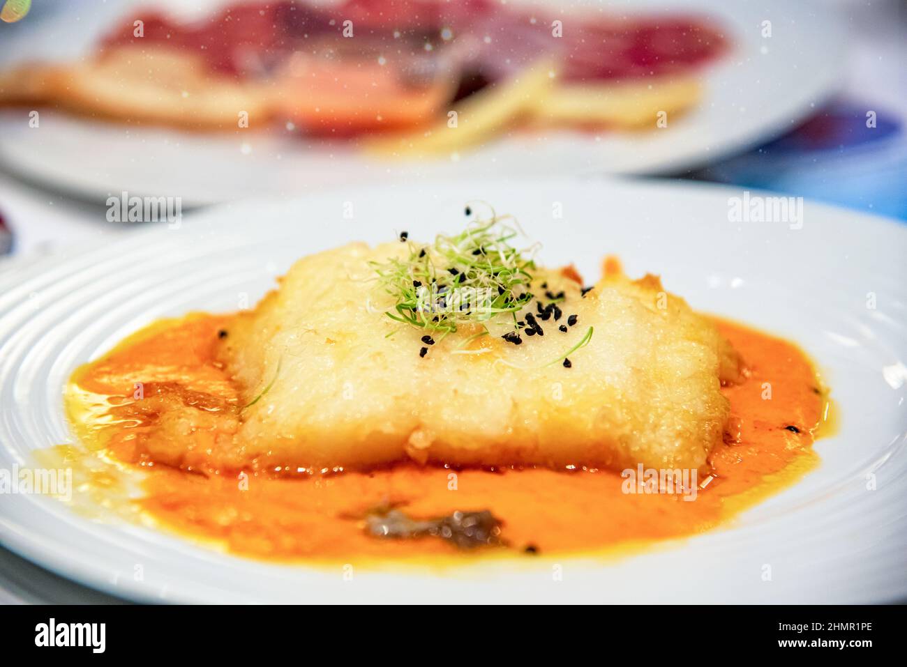white plate of hake with spices in sauce , front view Stock Photo - Alamy