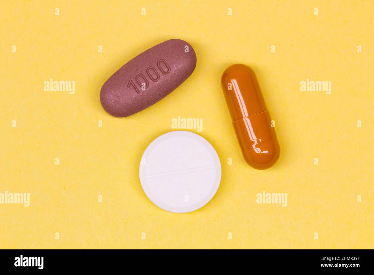 Multi-colored pills on a yellow background. Colorful medicines of ...