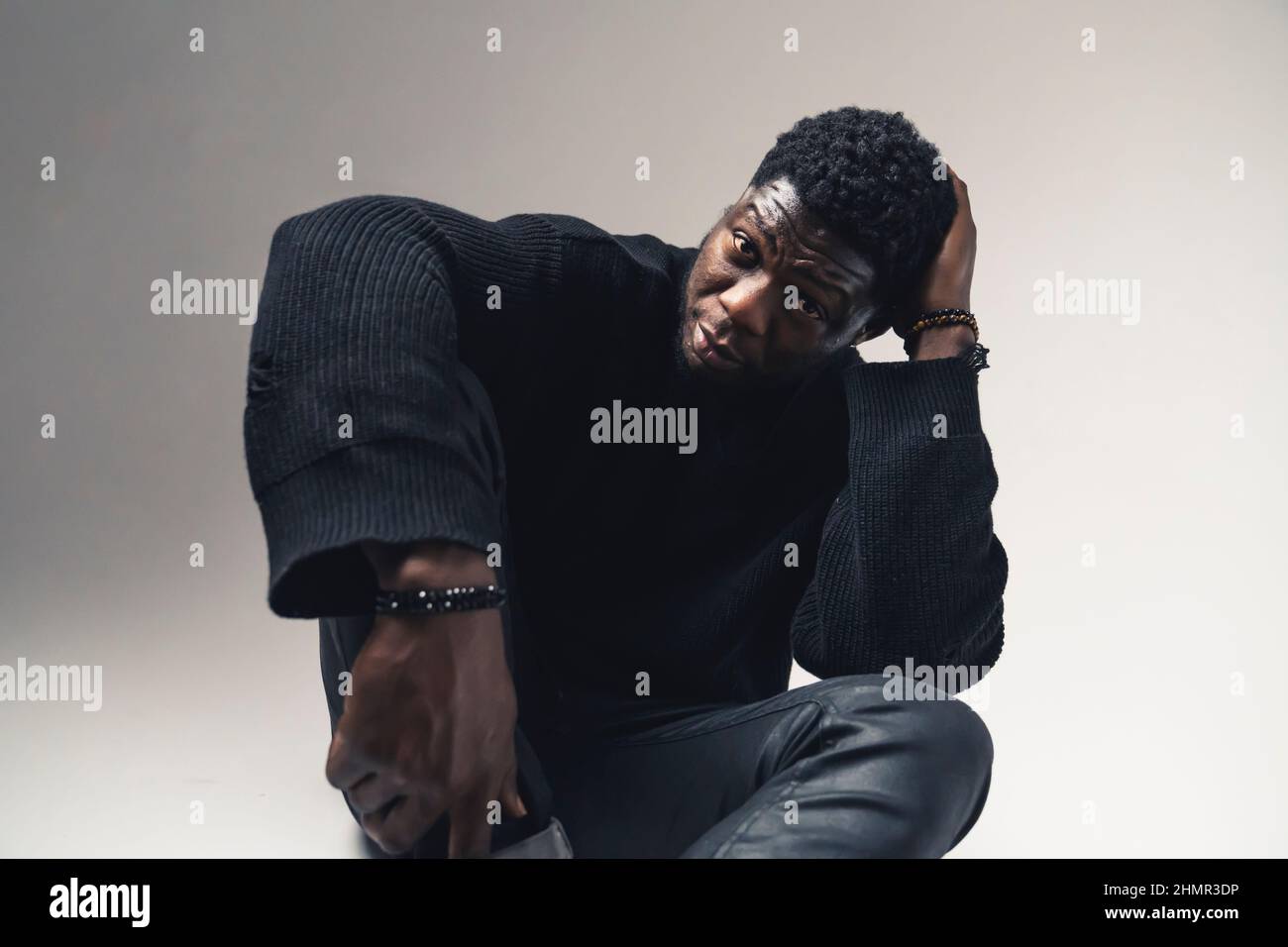black man seated scratching his head staring at the camera white ...