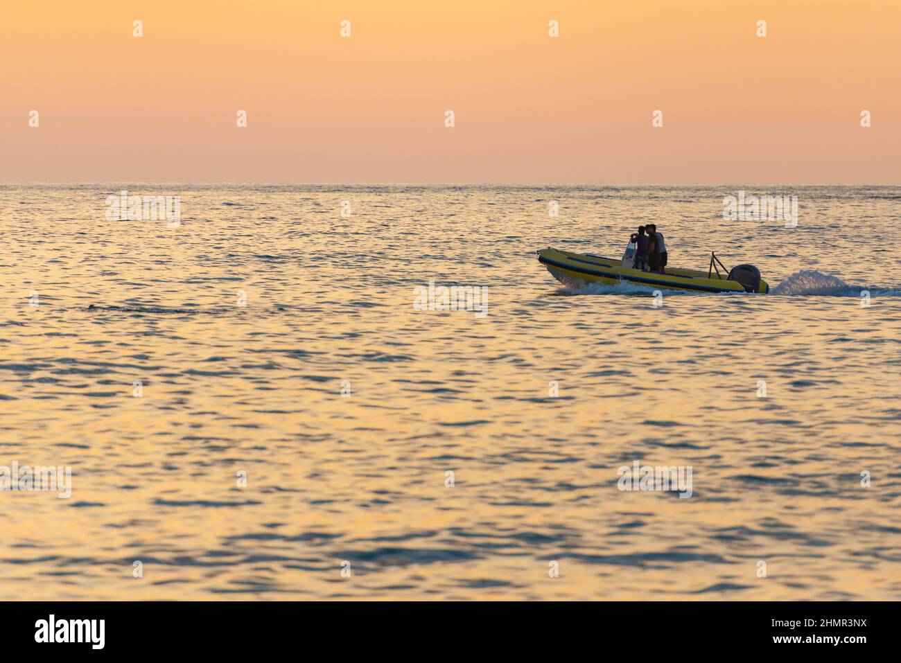 Motor boat at sea. A yellow rubber boat cleaves the calm sea in the ...