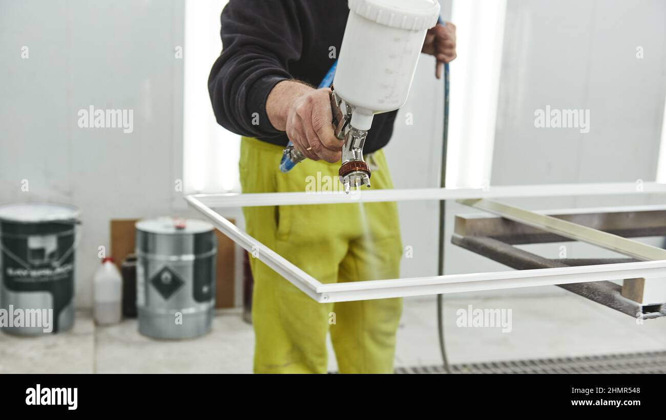 Bringing innovation to the surface. Man is holding airbrush spray ...