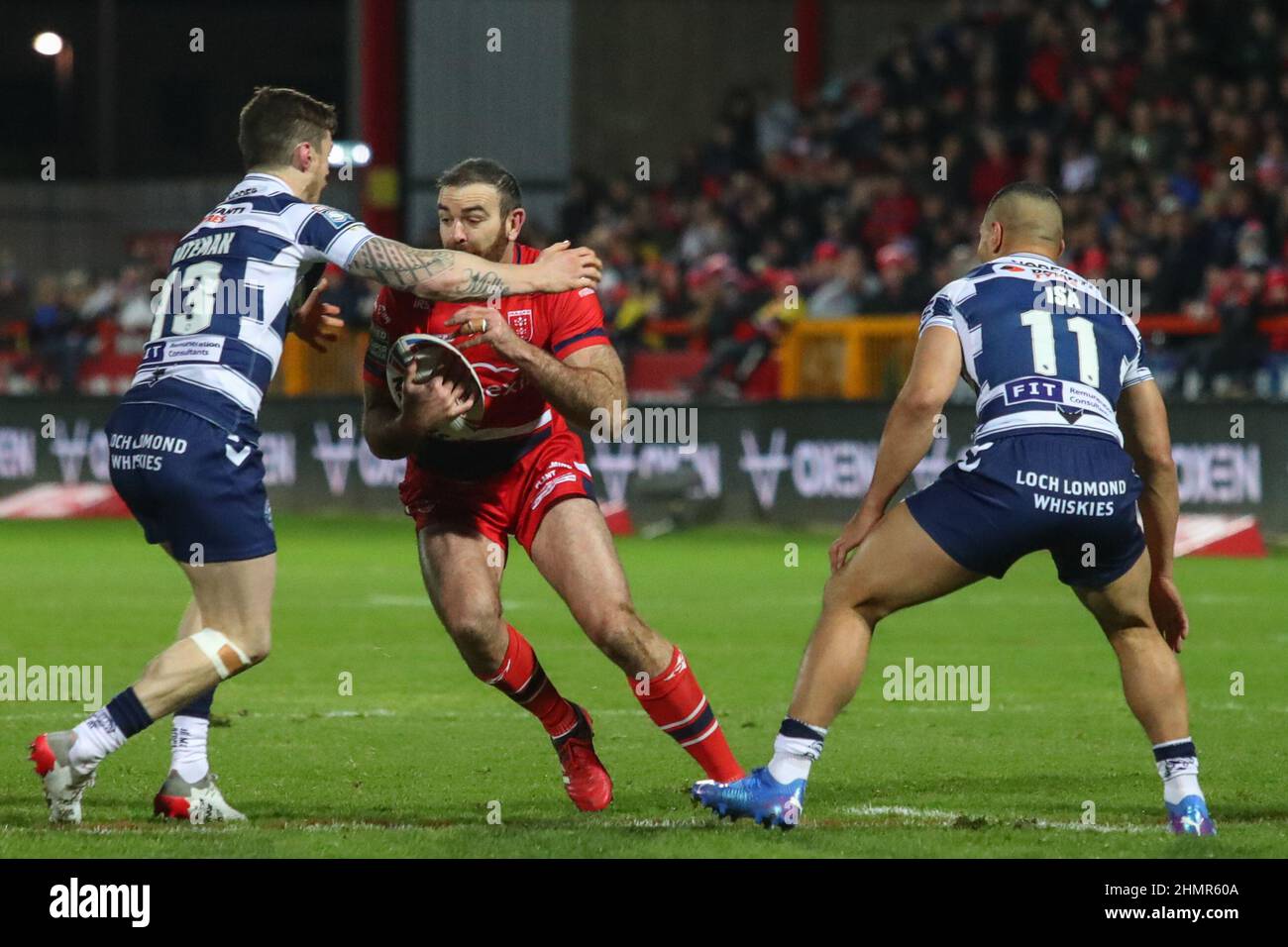 Kane Linnett #12 of Hull KR runs at John Bateman #13 of Wigan Warriors ...