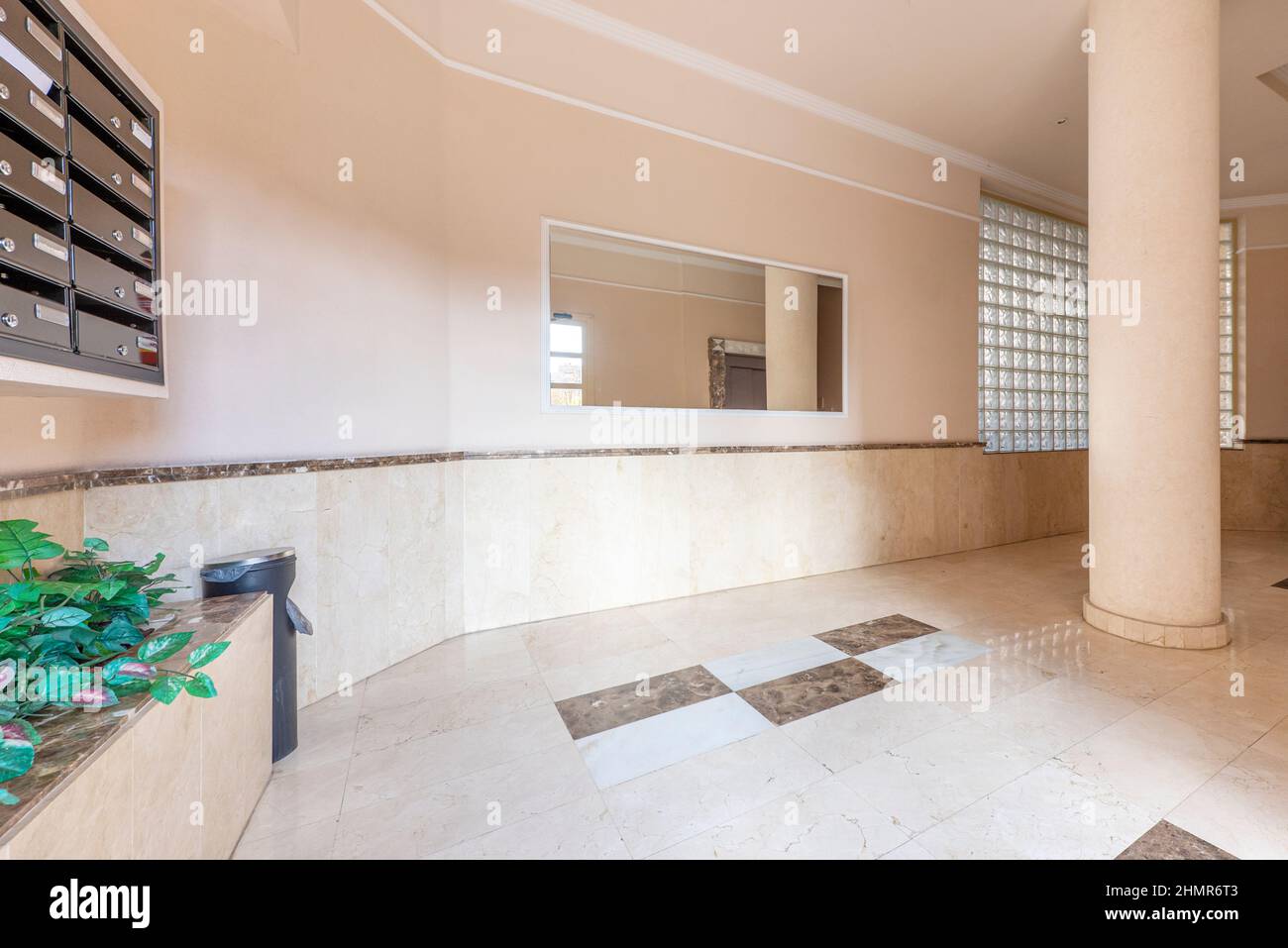 Entrance hall of a residential apartment building with walls tiled with ...
