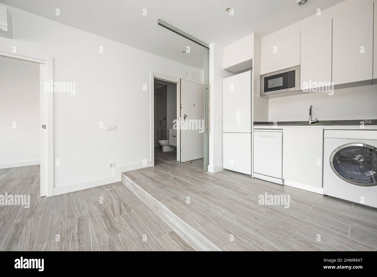 Living room and kitchen of apartment on two levels with white kitchen ...