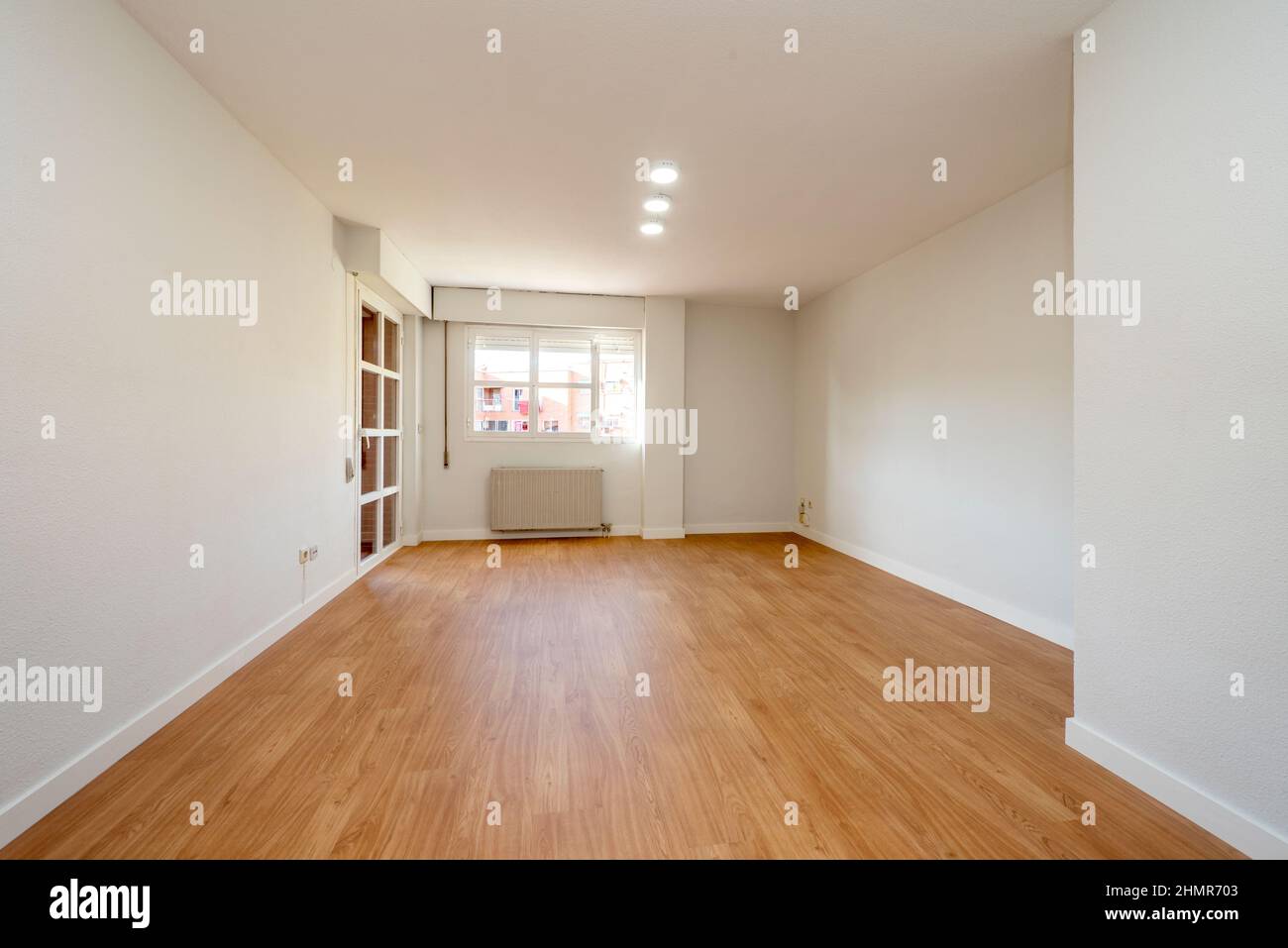 living room empty of furniture with wooden floors, freshly painted ...