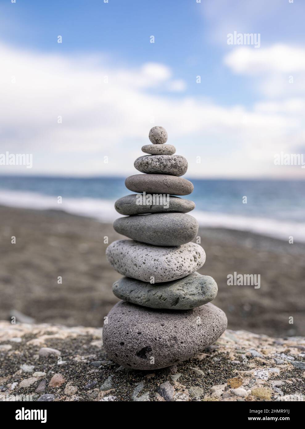 Stones stacked on the seashore under a blue sky Stock Photo - Alamy