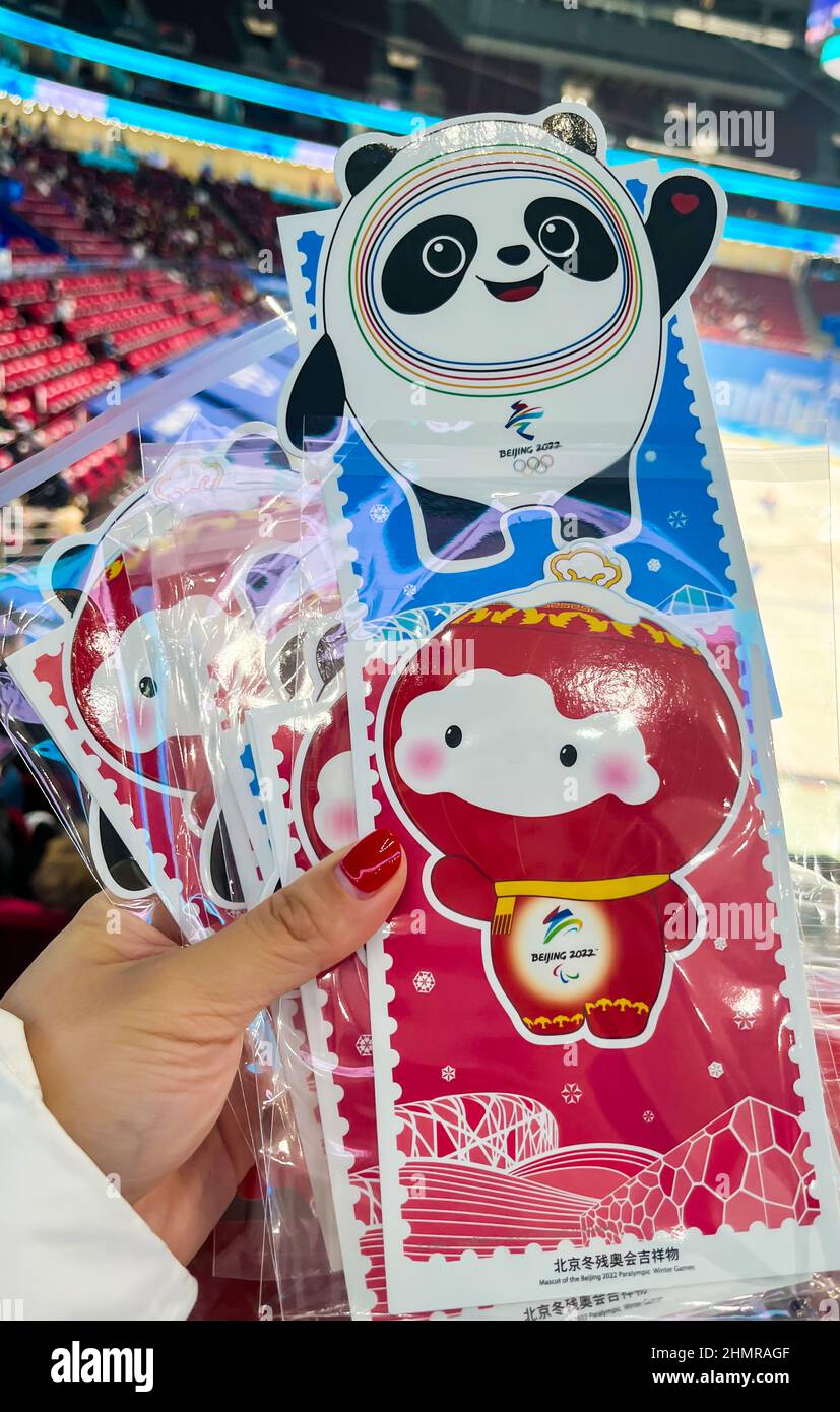 BEIJING, CHINA - FEBRUARY 12, 2022 - A visitor shows a postcard of mascots bought at the Beijing ...