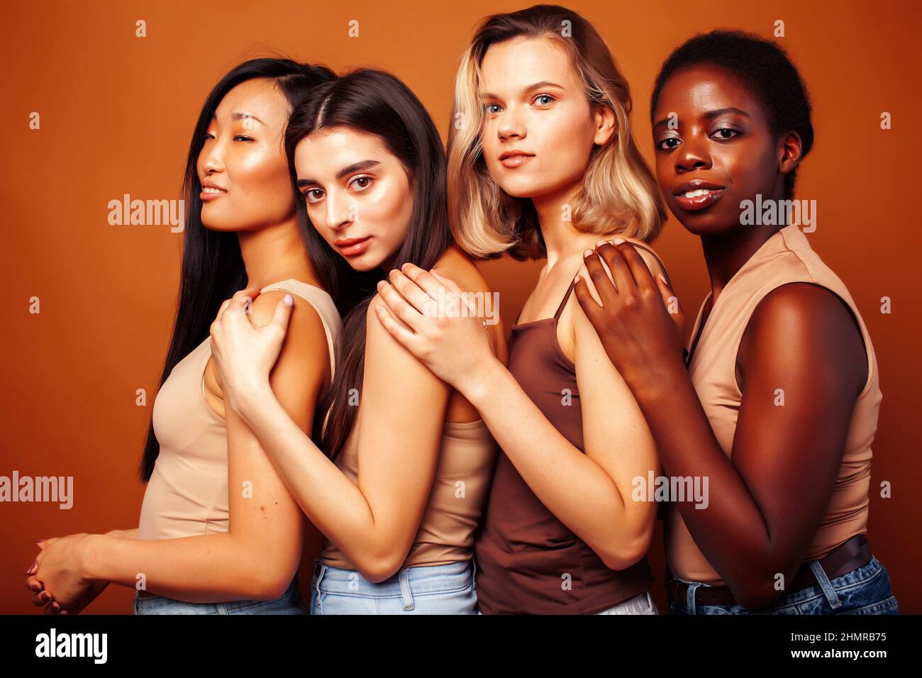 young pretty caucasian, african, scandinavian woman posing cheerful together on brown background ...