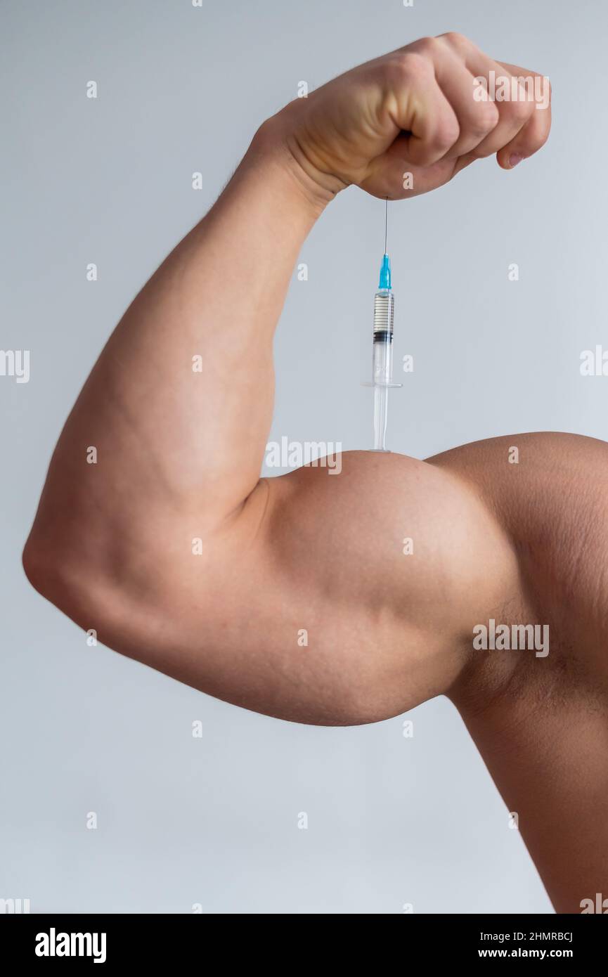 Close-up of male biceps. Unrecognizable male bodybuilder puts himself ...