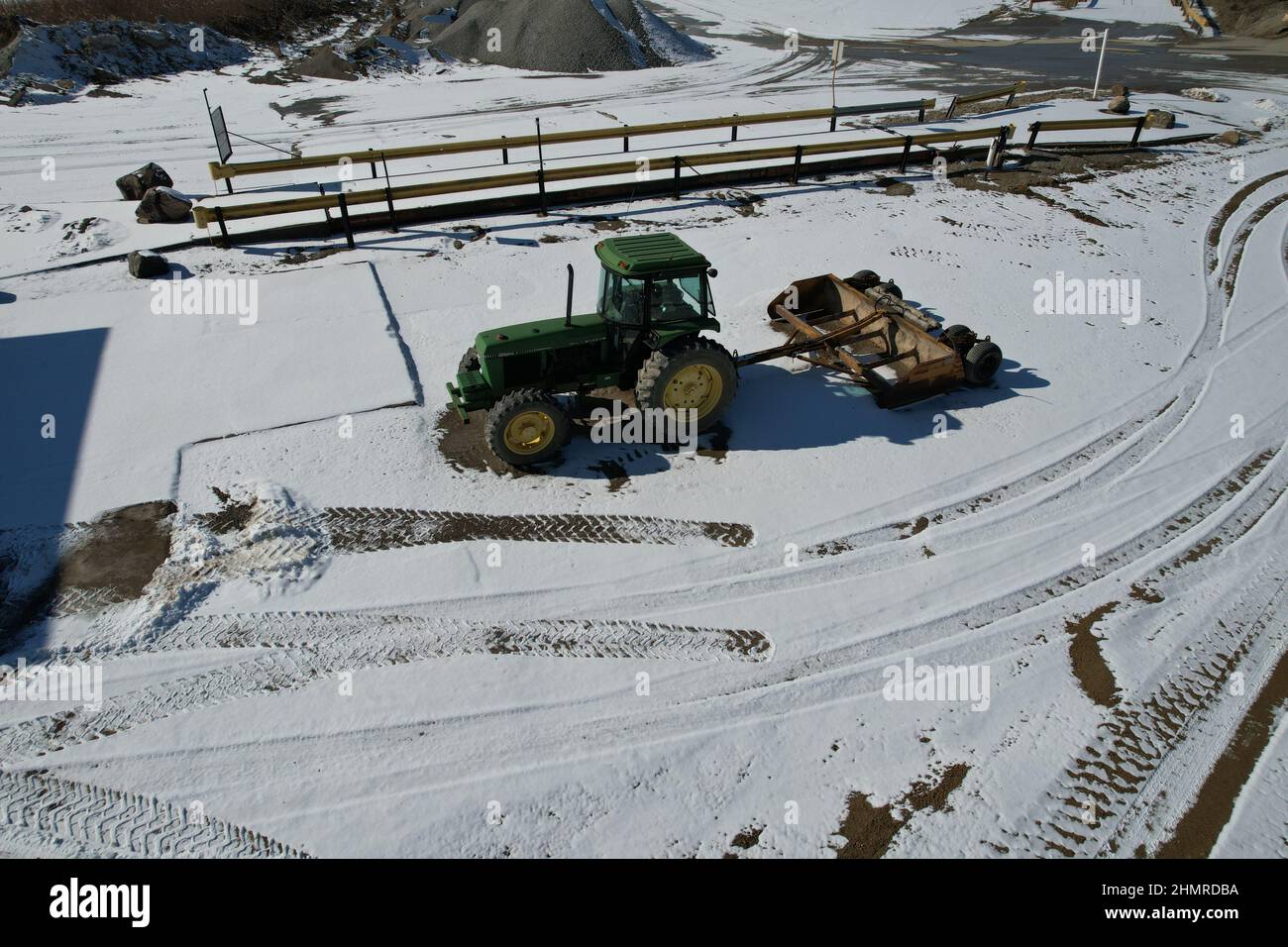 Green tractor standing on a snowy ground Stock Photo - Alamy