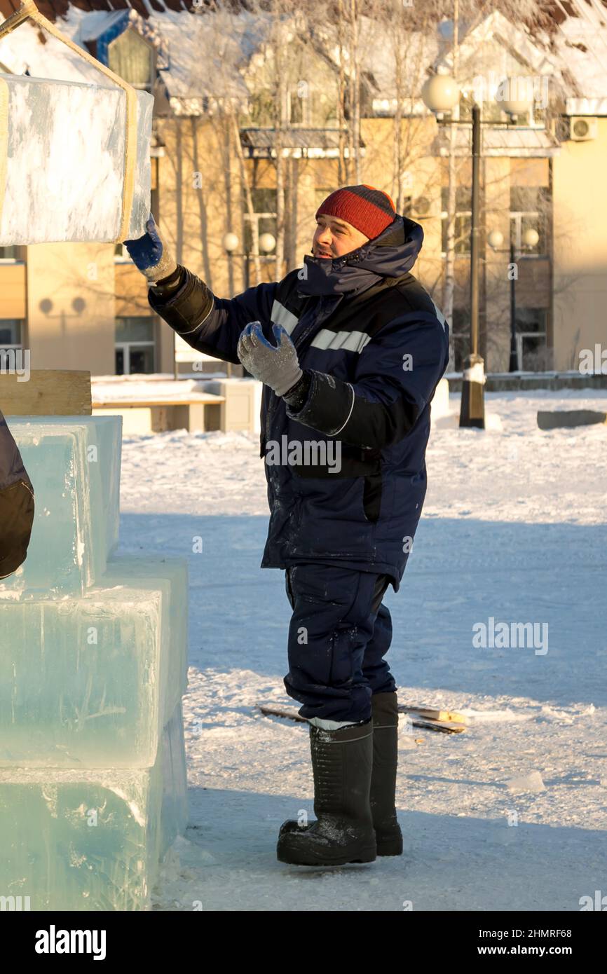 Fitter in a blue hooded jacket at an ice slab installation Stock Photo ...