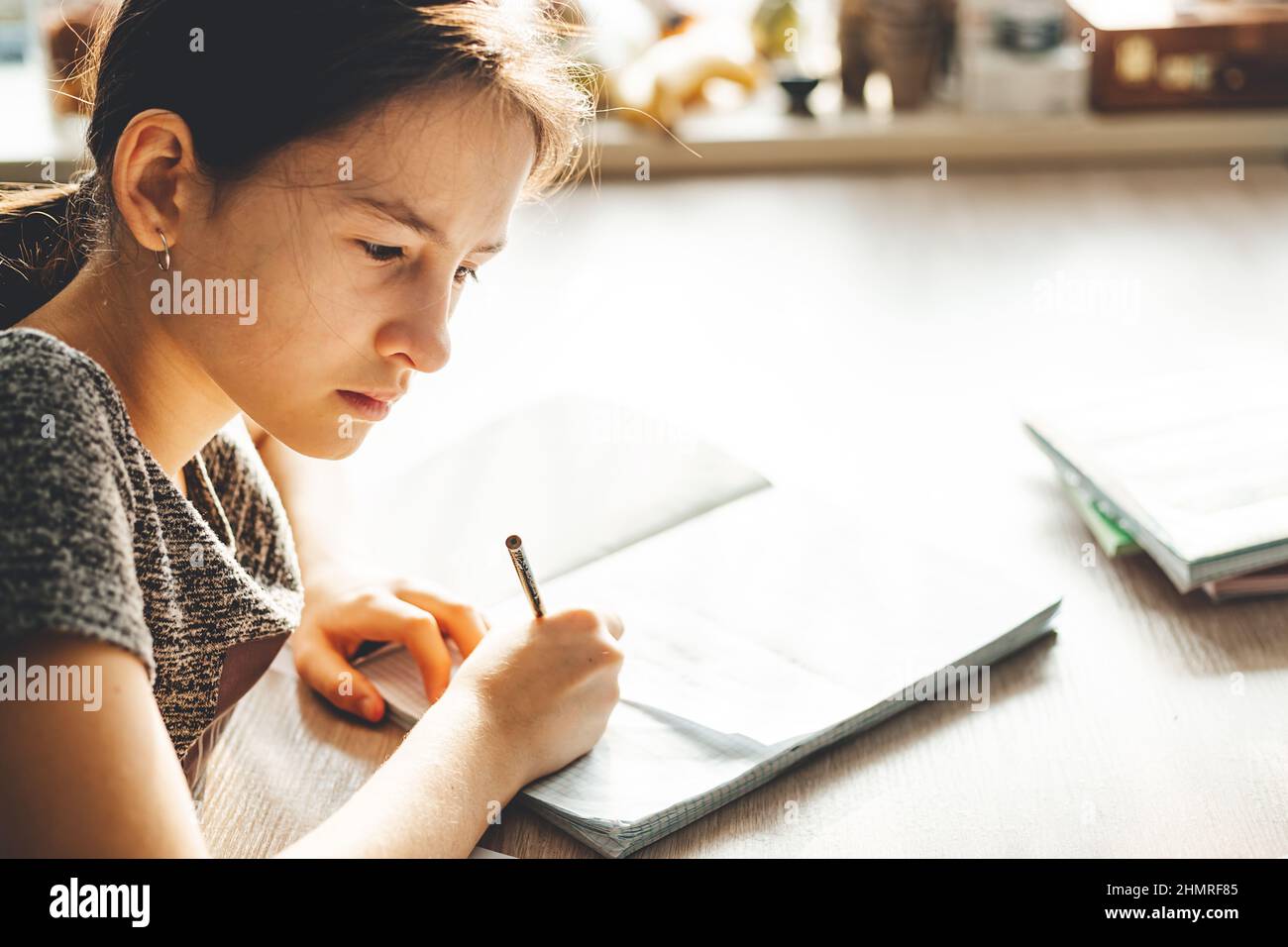 Teenage girl doing homework for school. Portrait of a pretty focused ...