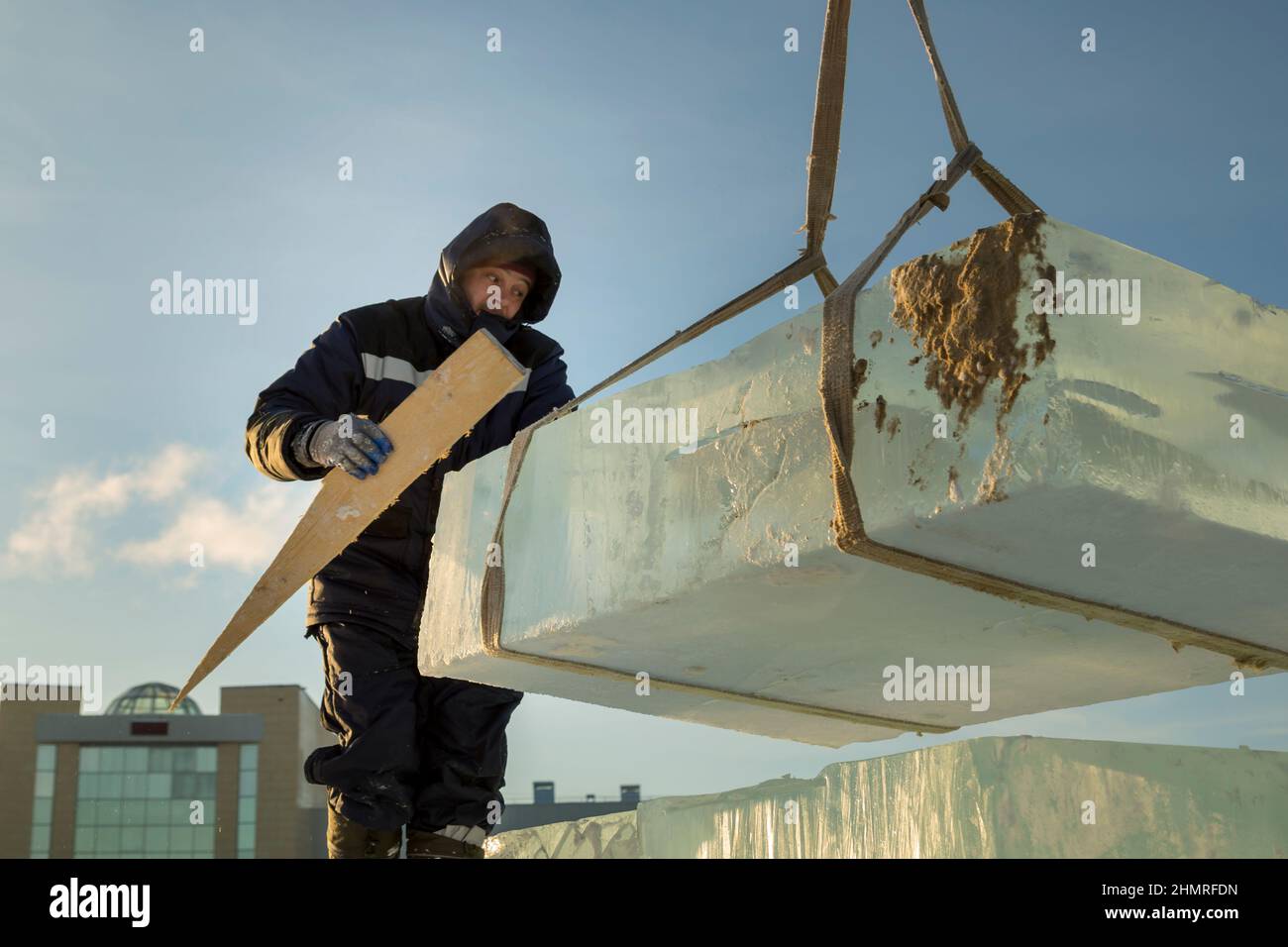 Fitter in a blue hooded jacket at an ice slab installation Stock Photo ...