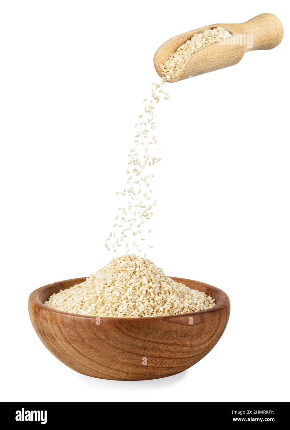 sesame seeds falling from scoop in wooden bowl Stock Photo - Alamy