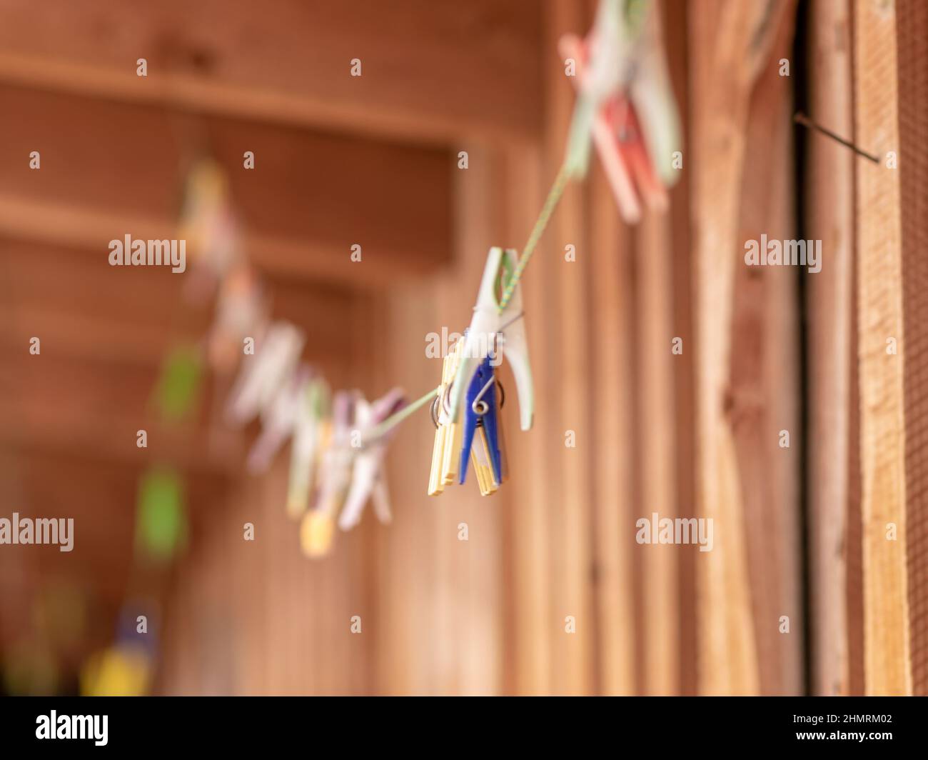 clothes pegs on clothesline, blurred background of wooden boards, close ...